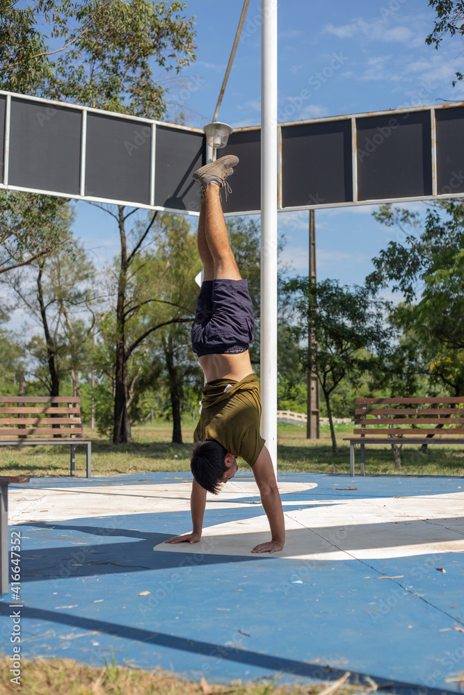 Hombre joven parado de manos en ñu guazu luque asunción con mucho calor ...