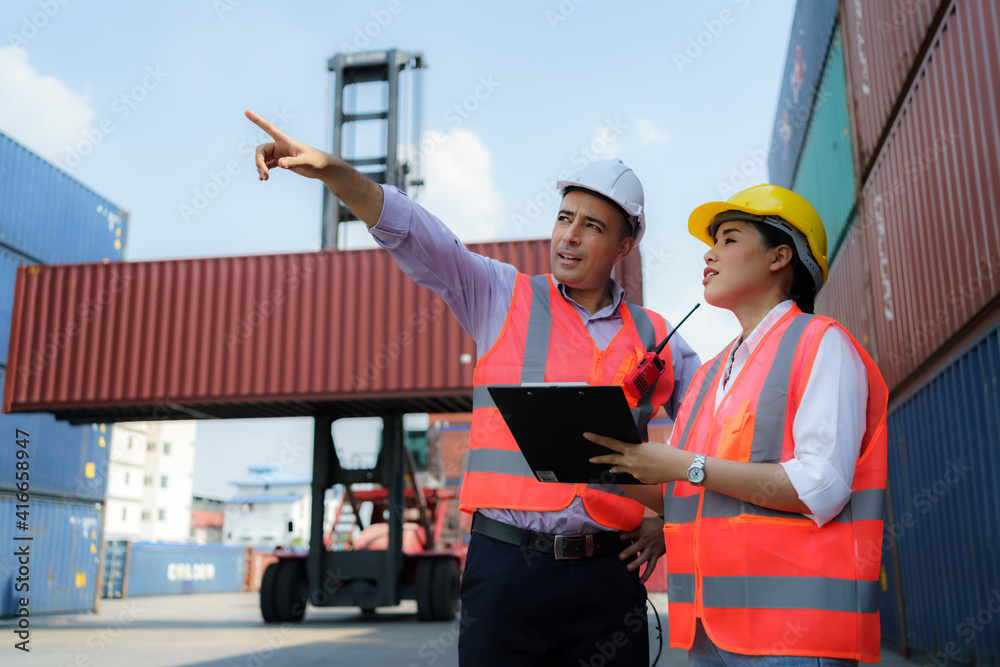 Asian female worker is explaining a check list of container inspections ...
