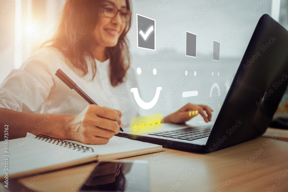 Businesswoman pressing face emoticon on the keyboard laptop .Customer ...