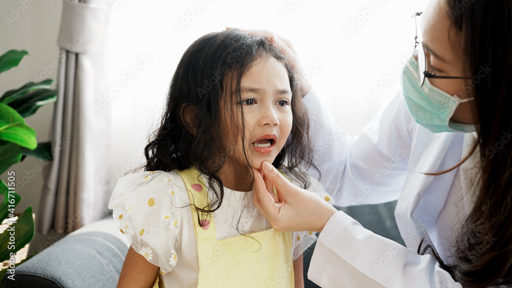 Asian little child crying because of a heavy toothache. Doctors are ...