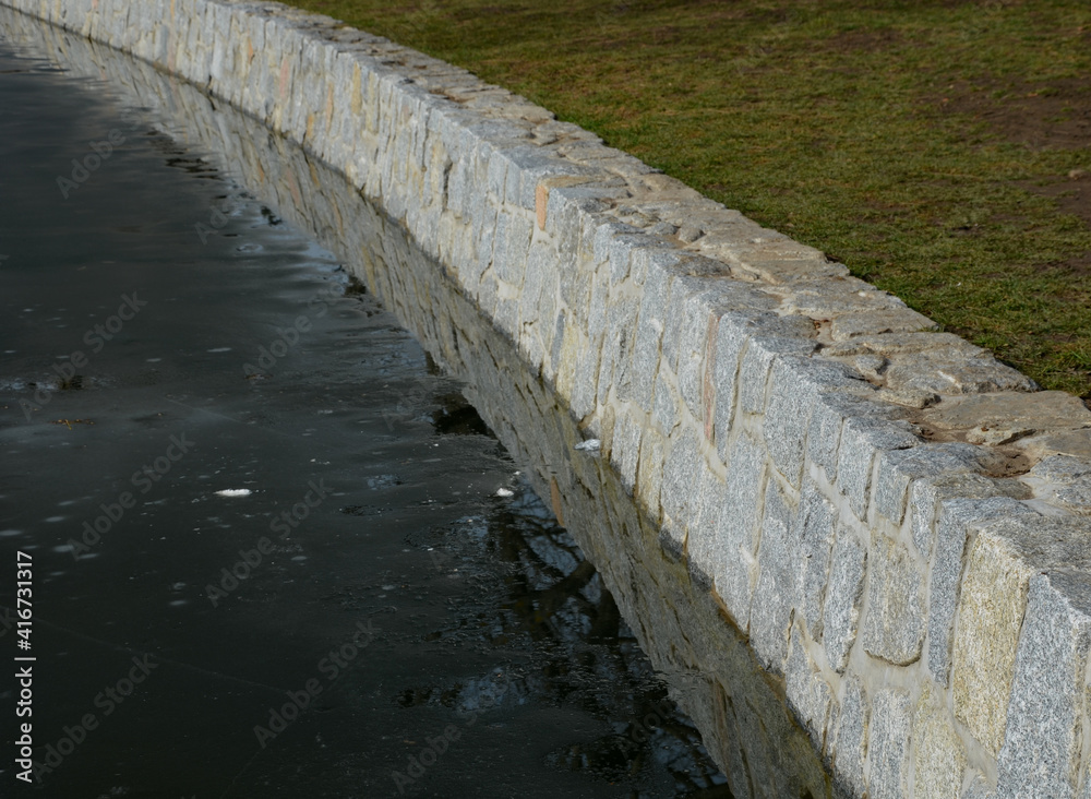 Stone retaining walls of a water reservoir or river pond dock ...