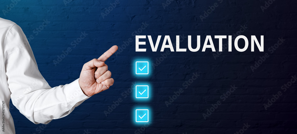Businessman hand points to the word evaluation with tick check mark ...