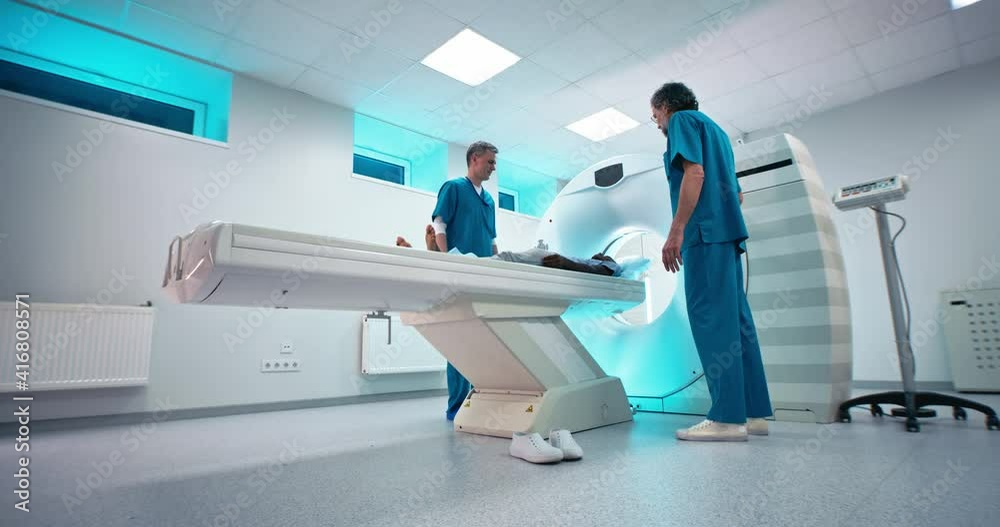 Male doctors escorting African American patient after CT scan Stock ...