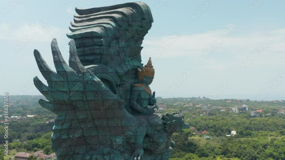 Side dolly aerial view of giant Garuda Wisnu Kencana statue in Bali ...