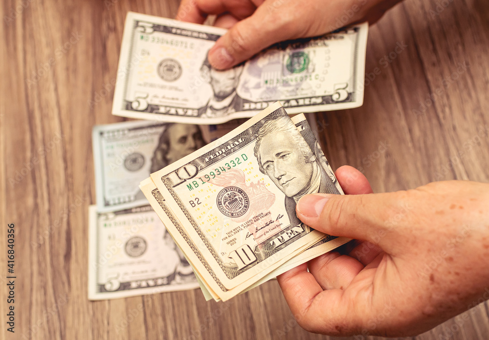 Dinheiro, Dólar americano - USD. Uma mulher contando cédulas de dólar ...