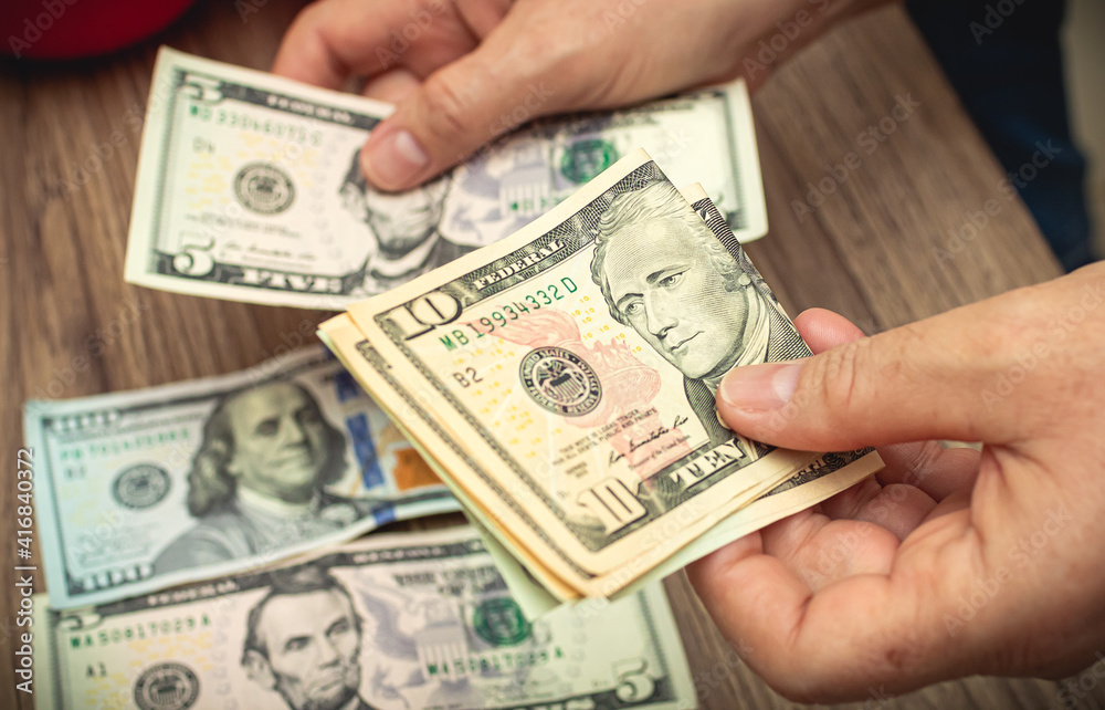 Dinheiro, Dólar americano - USD. Uma mulher contando cédulas de dólar ...