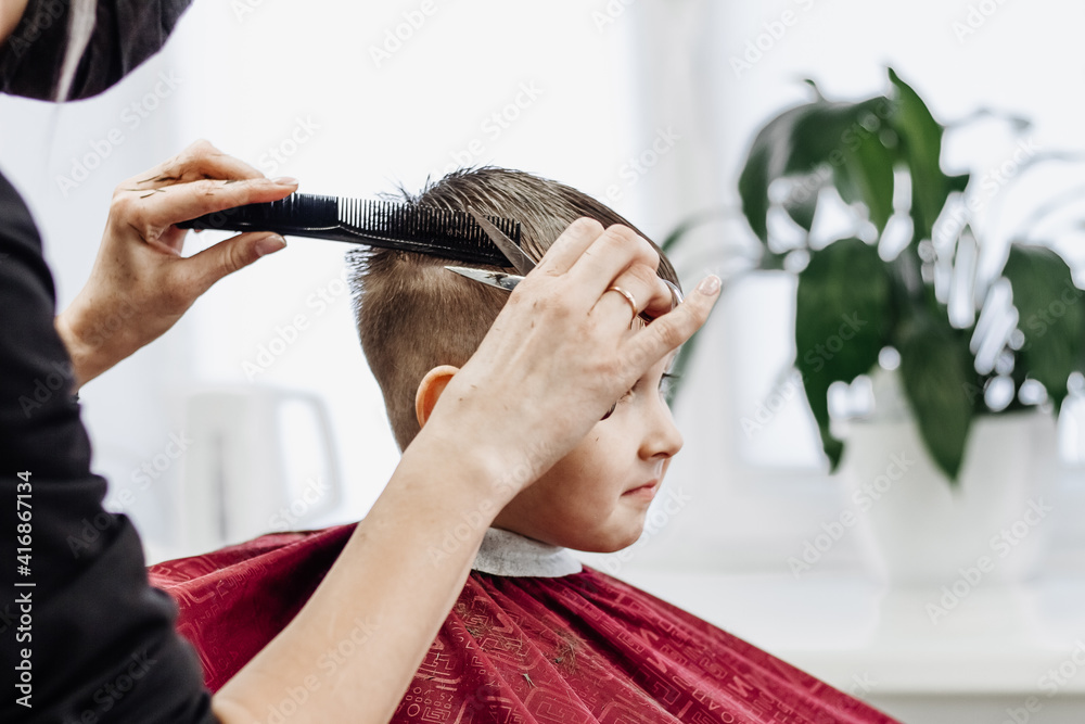 Close-up of woman hands grooming kid boy hair in barber shop. Stock ...