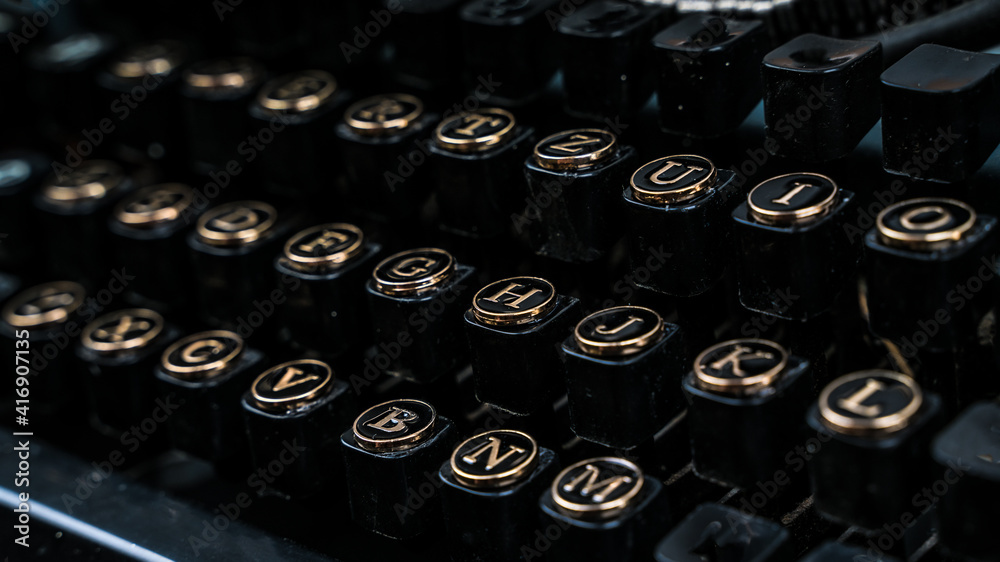 Gold keys of an old vintage typewriter. Alphabet keyboard. on black ...