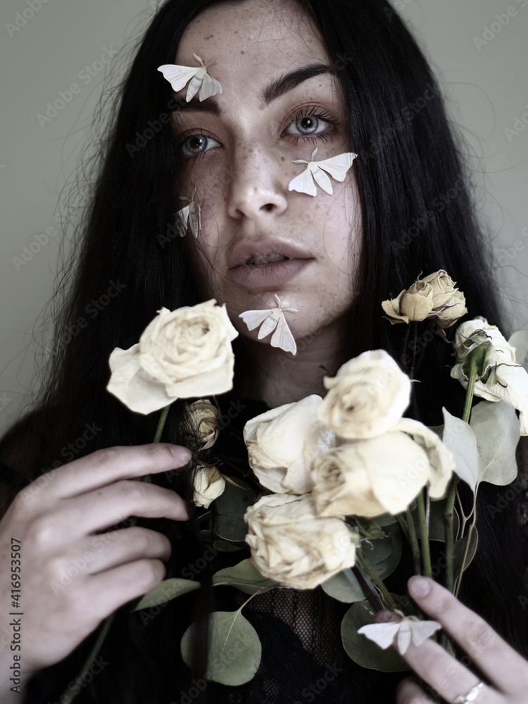 a young gothic girl pale with freckles with moths on her face and ...