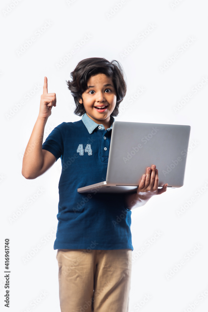 Indian cute little boy working on laptop while standing isolated Stock ...