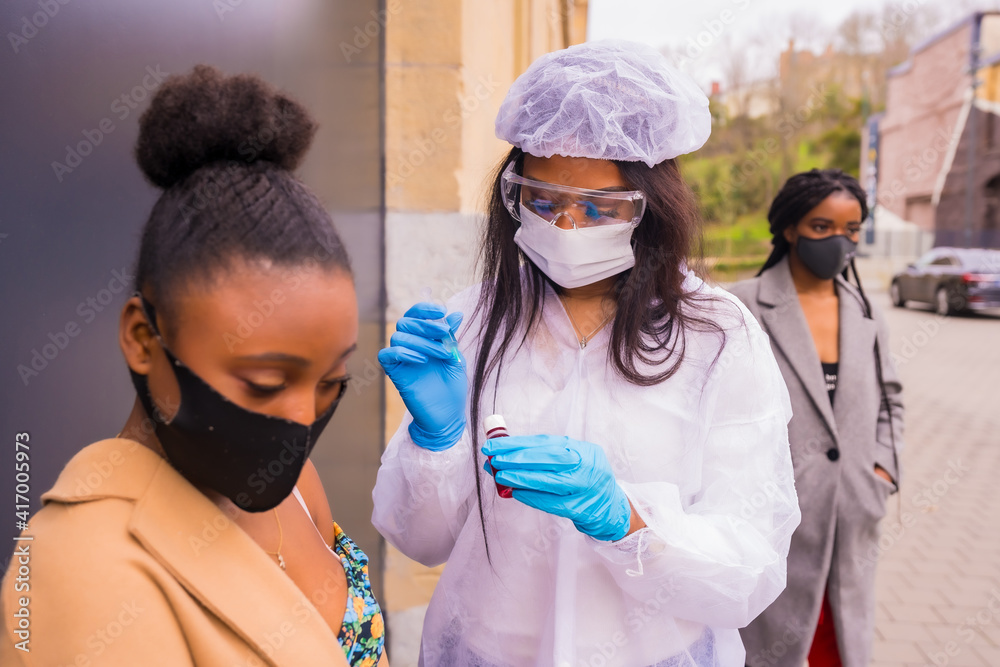 Black girl receiving the injection of the coronavirus vaccine by a ...