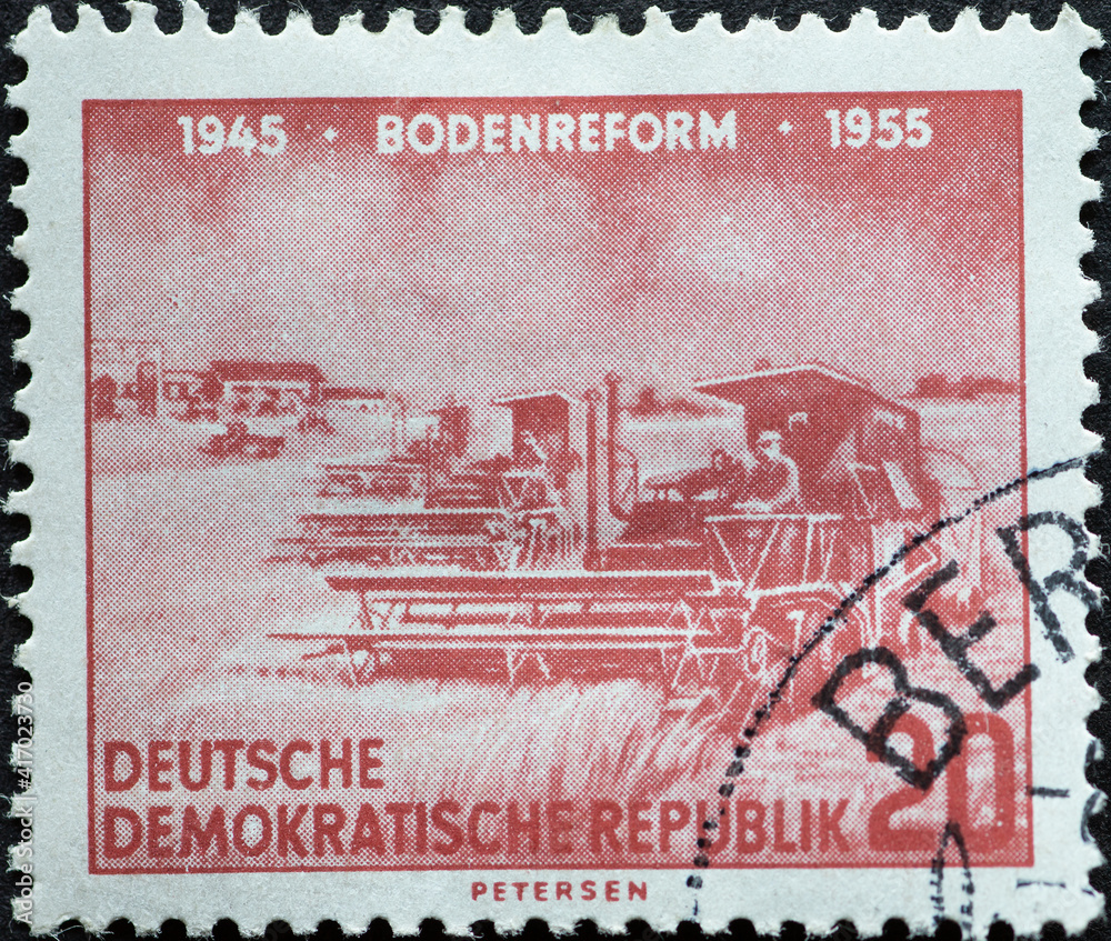 GERMANY, DDR - CIRCA 1955 : a postage stamp from Germany, GDR showing a combine harvester in ...