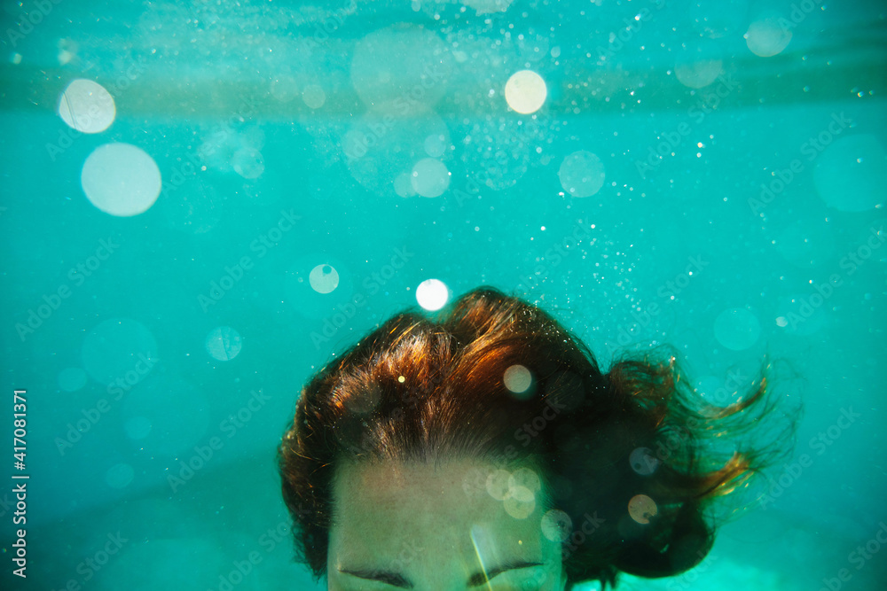 Horizontal view of unrecognizable woman diving into deep water. Blue ...