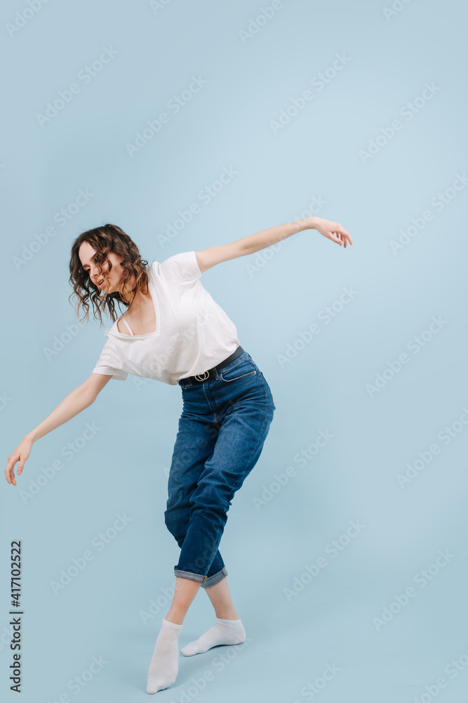 Artistic contemporary dancer poses in front of blue studio background ...