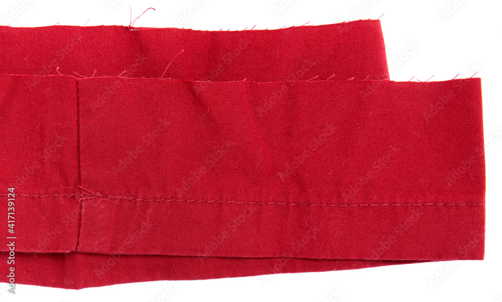 Red twill sample textile showing seam allowance and tattered threads ...