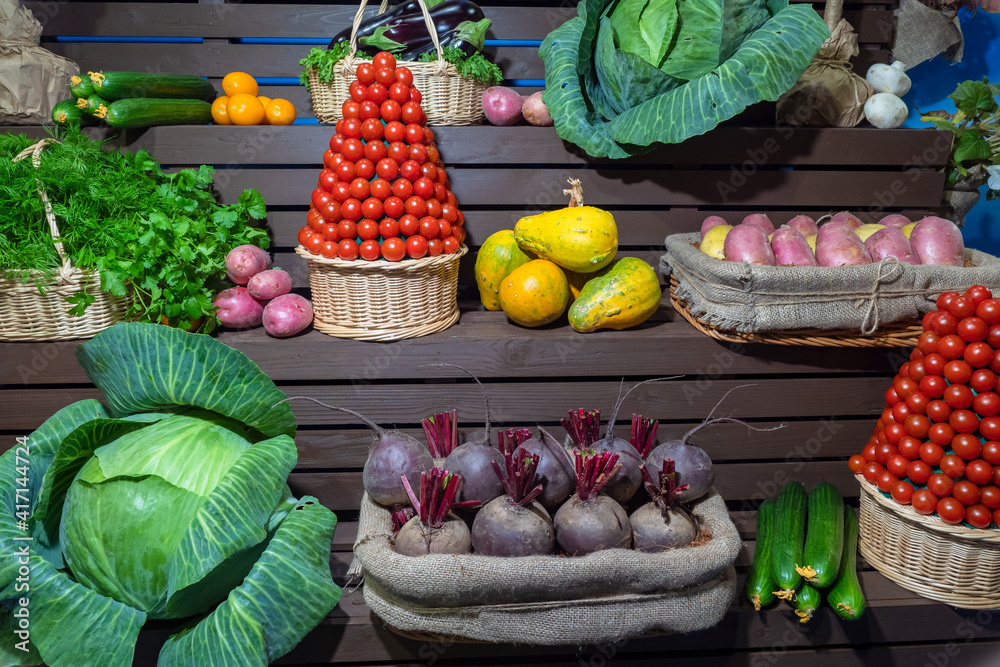 Many different vegetables are displayed on wooden counter. Stepped dark ...