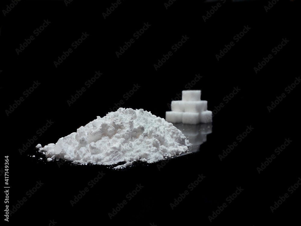 Cocaine drug powder pile and ump sugar cubes on black background, sugar ...
