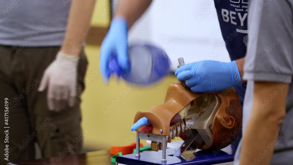 Training course on dummy head. Practitioner in medical gloves ...