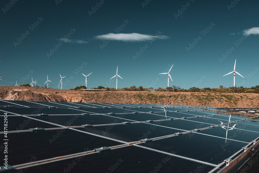 Wind farm and solar panels under a beautiful blue sky with a few clouds ...