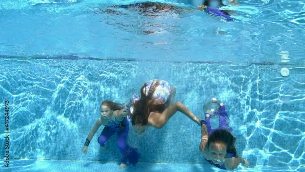 Video Stock Three adorable little girls swim underwater in an outdoor ...