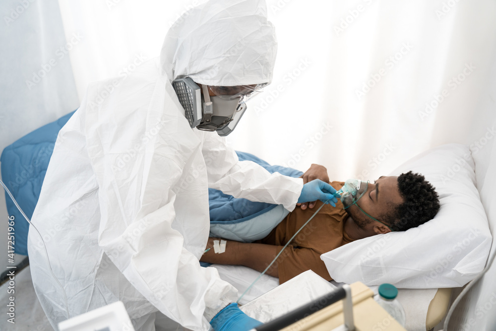 Medical worker giving oxygen mask to the male patient with covid-19 ...