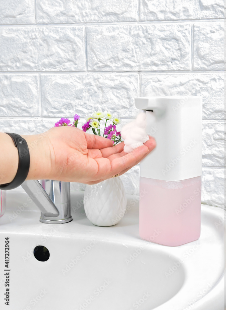 female hand using Automatic touchless soap dispenser in bathroom . hand ...