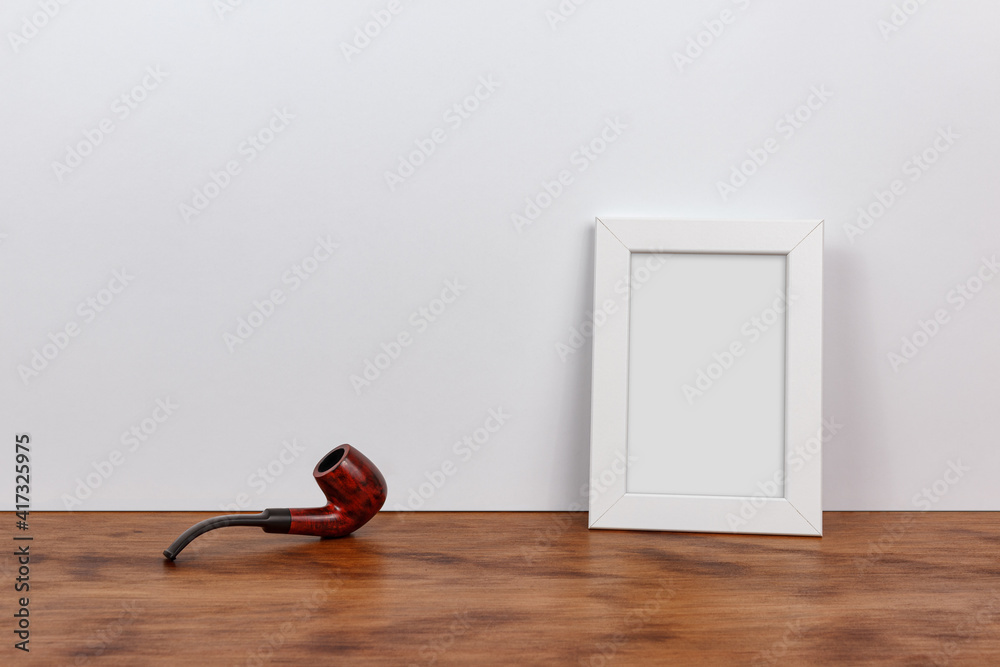 Minimalist still life of a customizable picture frame and smoking pipe ...