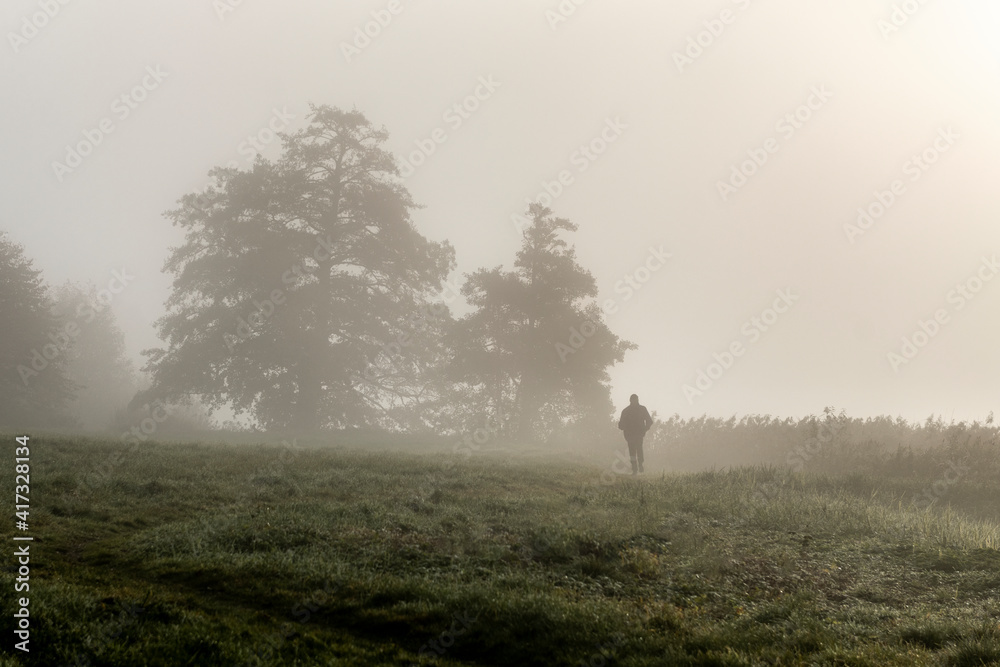 Alone man walking in fog Stock Photo | Adobe Stock