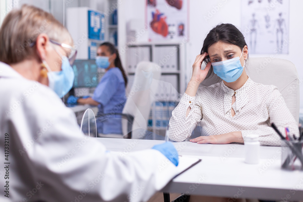 Young patient feeling sad receving bad news from senior doctor during ...