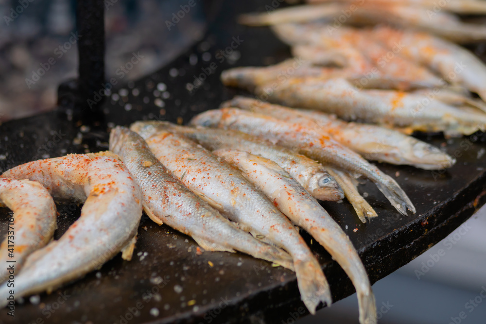 Process of cooking european smelt fish with red paprika powder on black ...