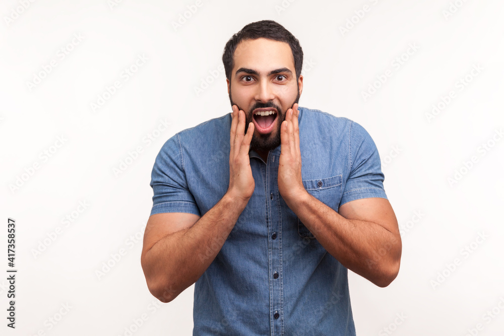 Excited shocked man holding hands on face and screaming looking at ...