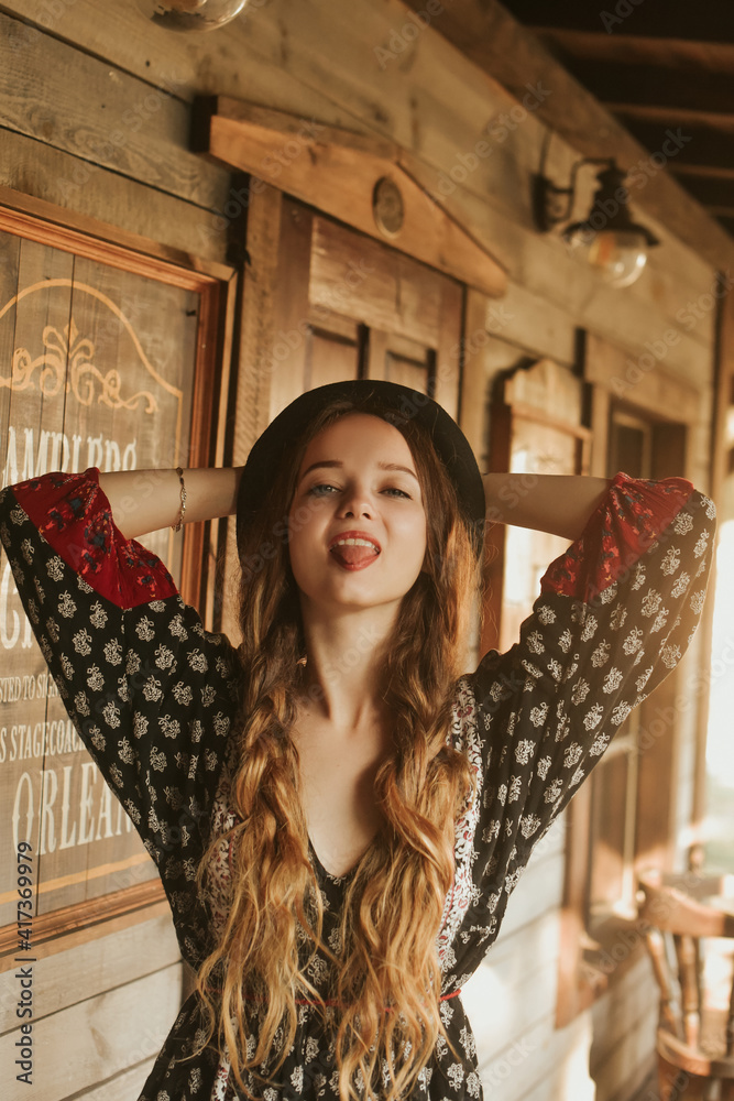 Girl in the Wild West, in Western house. Girl in hat with long cerly ...