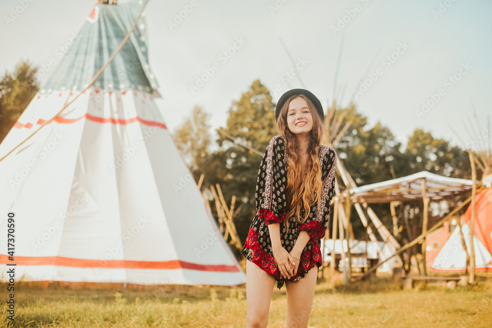 Young beautiful girl smiling on background teepee, tipi- native indian ...