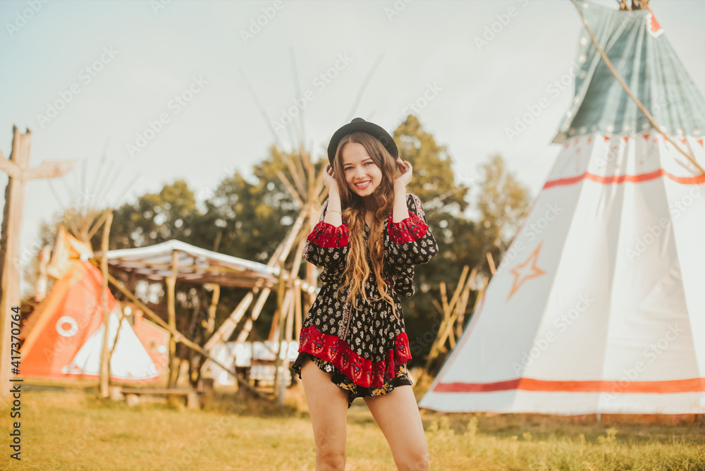 Young beautiful girl smiling on background teepee, tipi- native indian ...