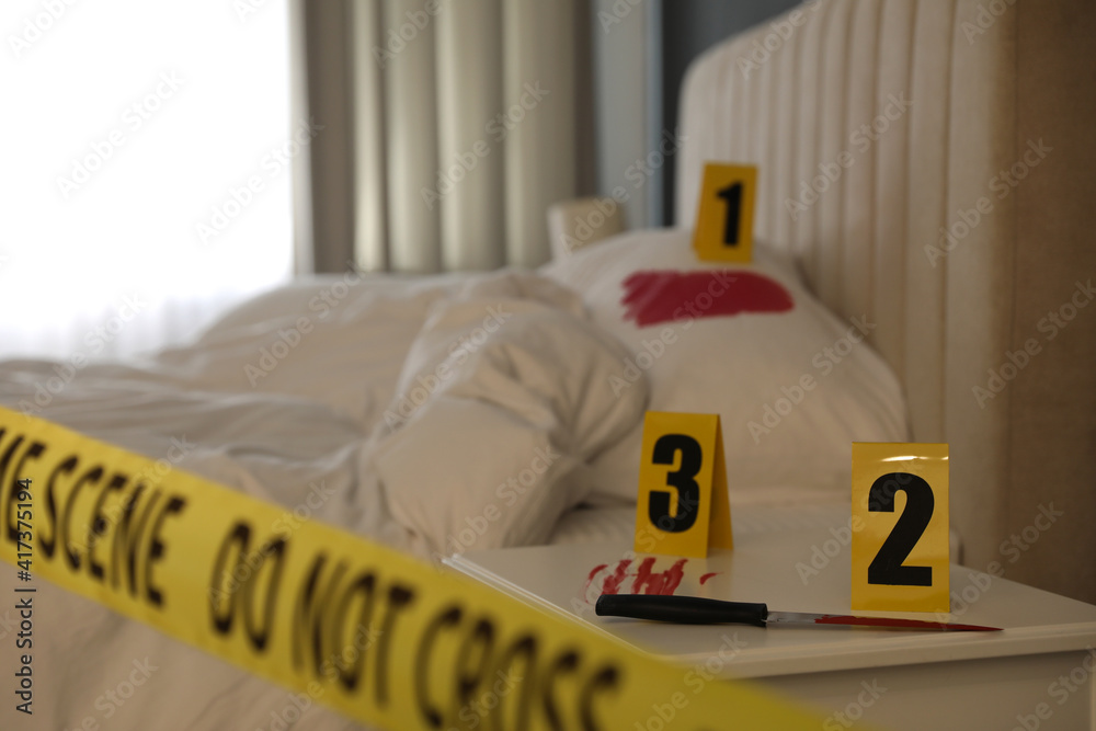 Bloody knife and crime scene markers on nightstand in bedroom Stock ...