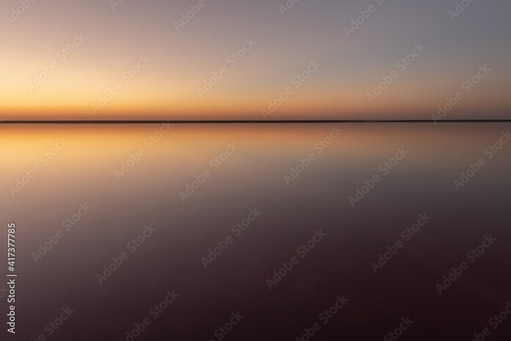 Tranquil minimalist landscape with smooth surface of the pink salt lake ...
