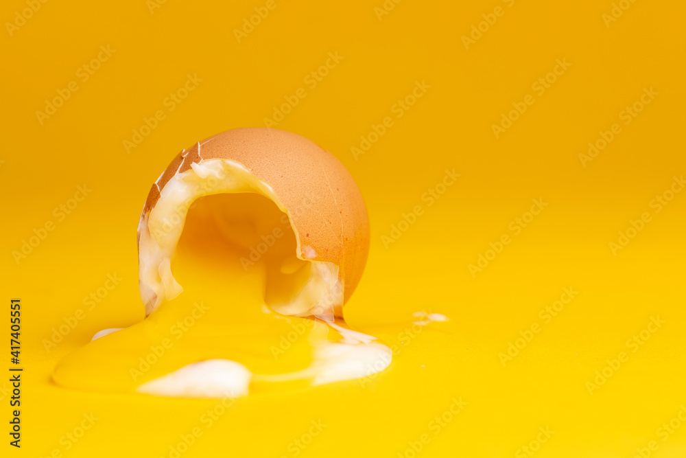 Spilling of fallen over broken shell of soft cooked egg with the slimy ...