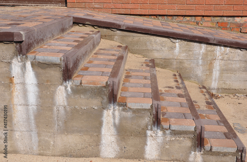 A close-up on concrete stairs and wheelchair ramp under construction ...