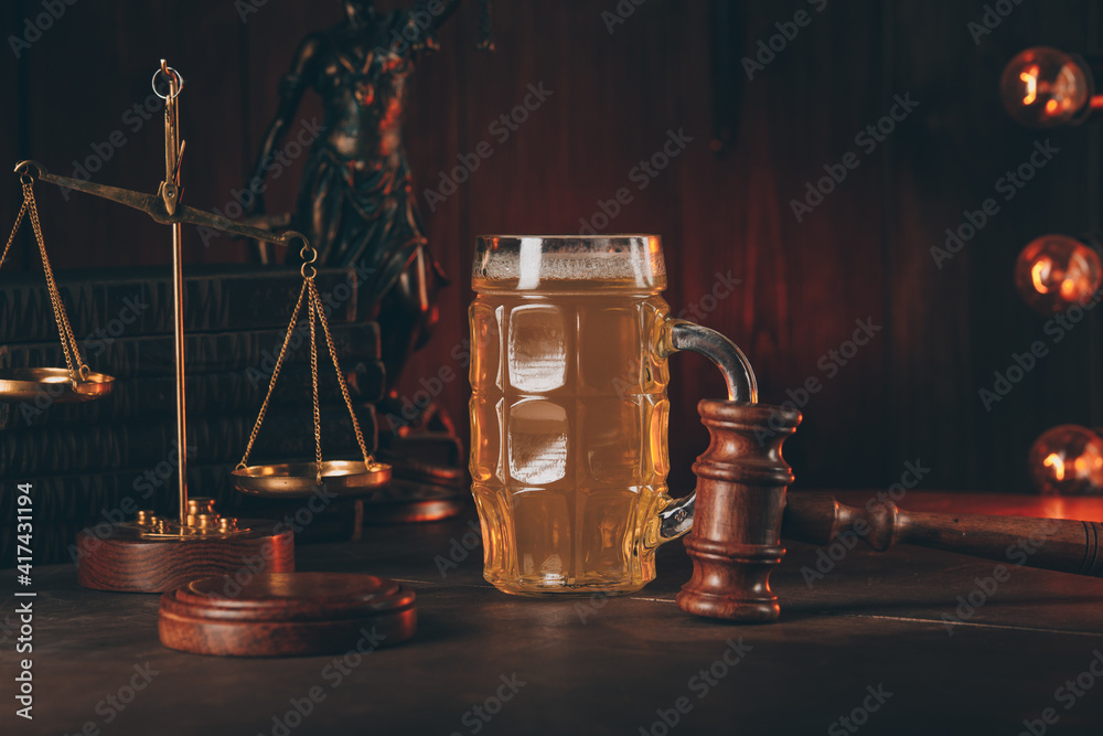 Glass of beer and judge gavel in a courtroom. Alcohol and crimes ...