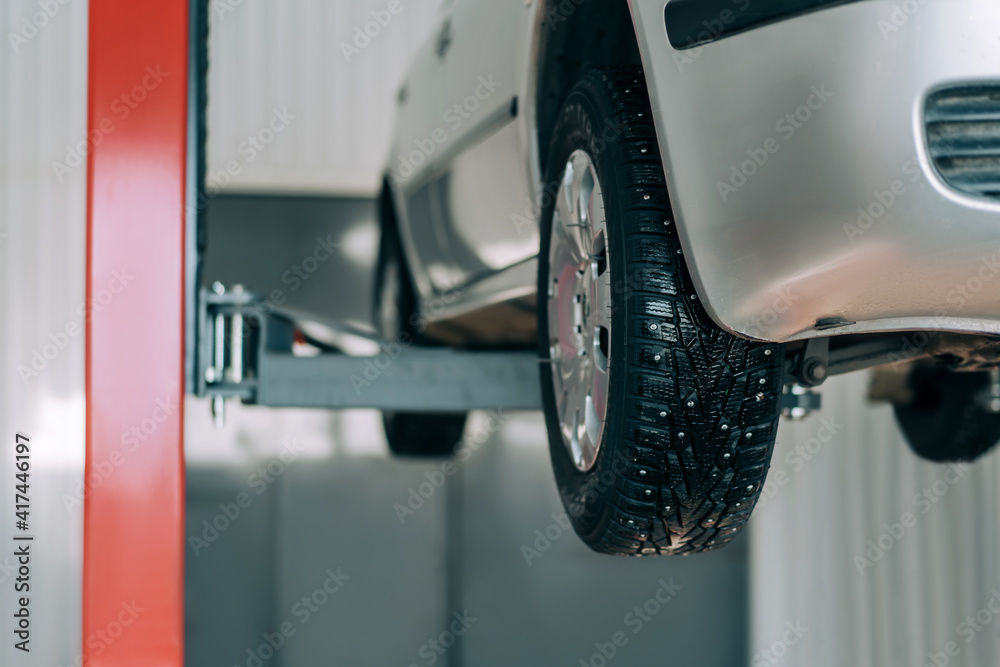 The machine is lifted on a car lift for repair. Side view of the car ...