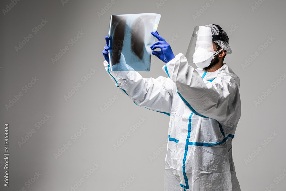 A man doctor examines an X-ray of a patient s lung infected with covid ...