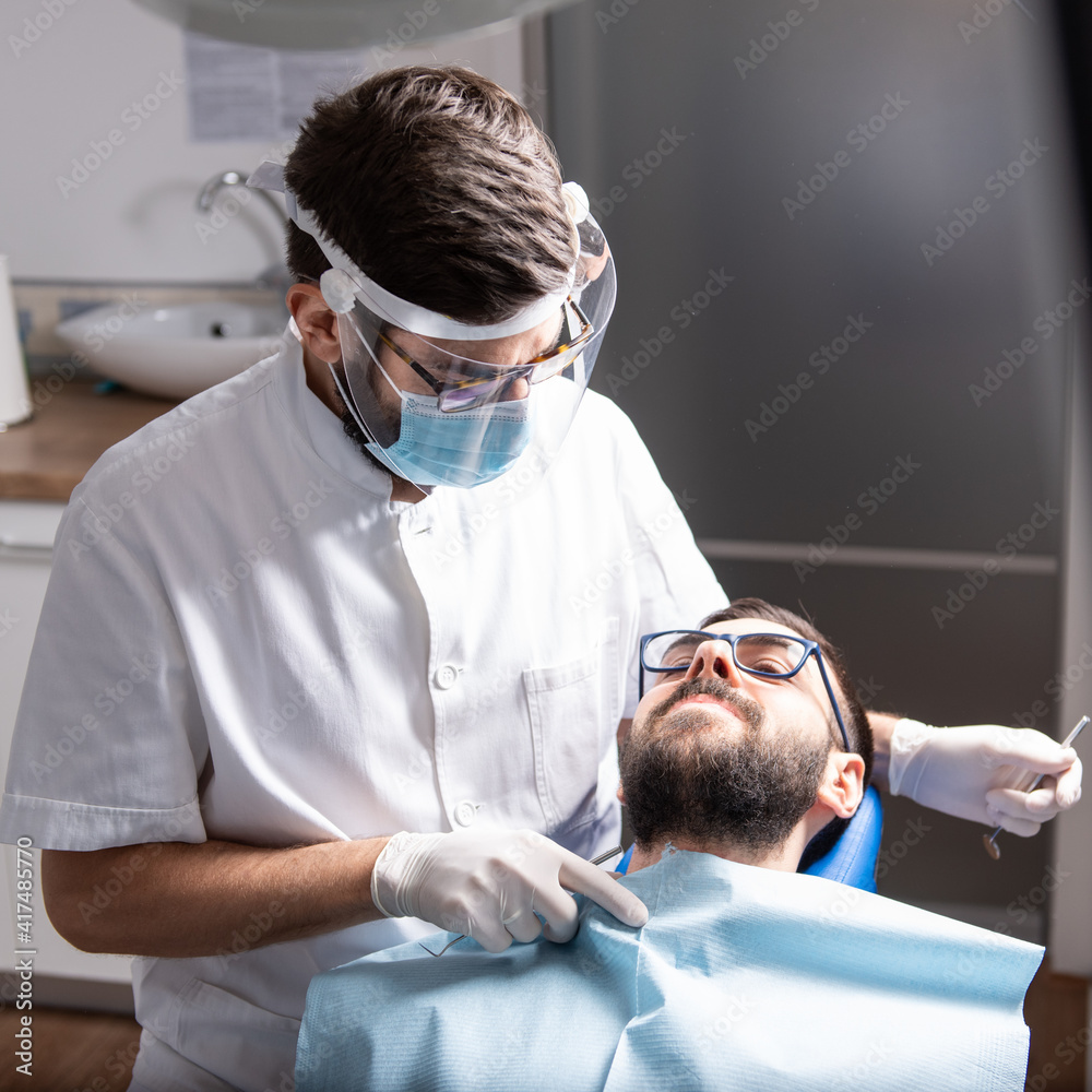 Dentist performs a regular examination of the patient Stock Photo ...