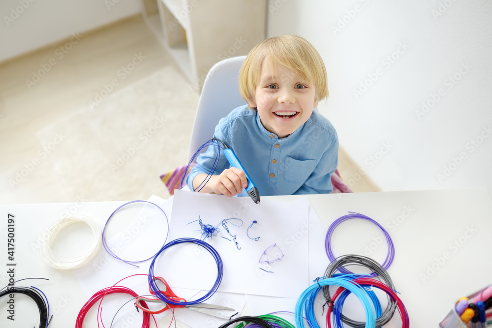 Little boy learning make model with 3d printing pen. Child playing with ...
