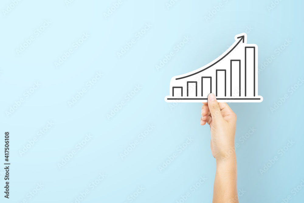 Hand holding paper with arrow and graph increase on light blue ...