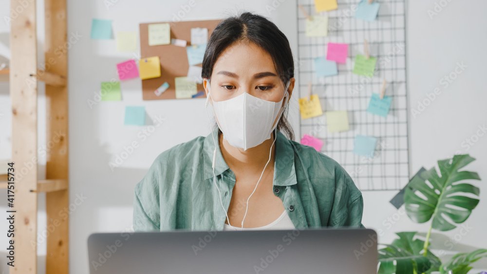 Asia businesswoman wearing medical face mask using laptop talk to ...