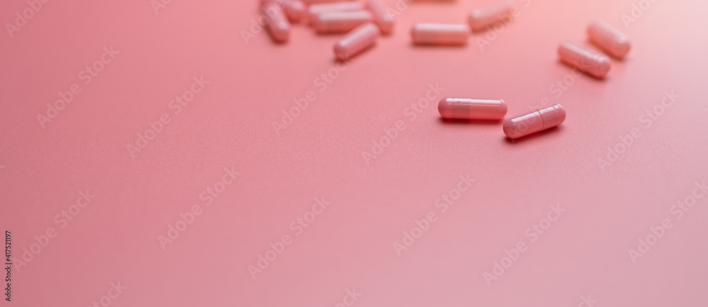 Pink capsules pill spread on pink background. Vitamins and supplements ...