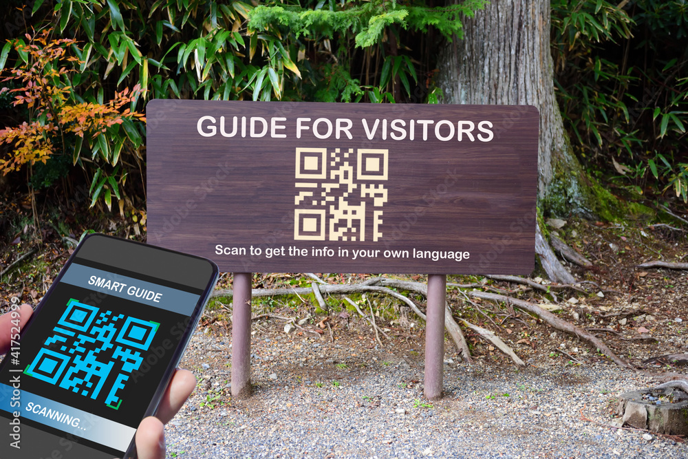 Hand holding smartphone with scanning QR code travel guide screen with ...