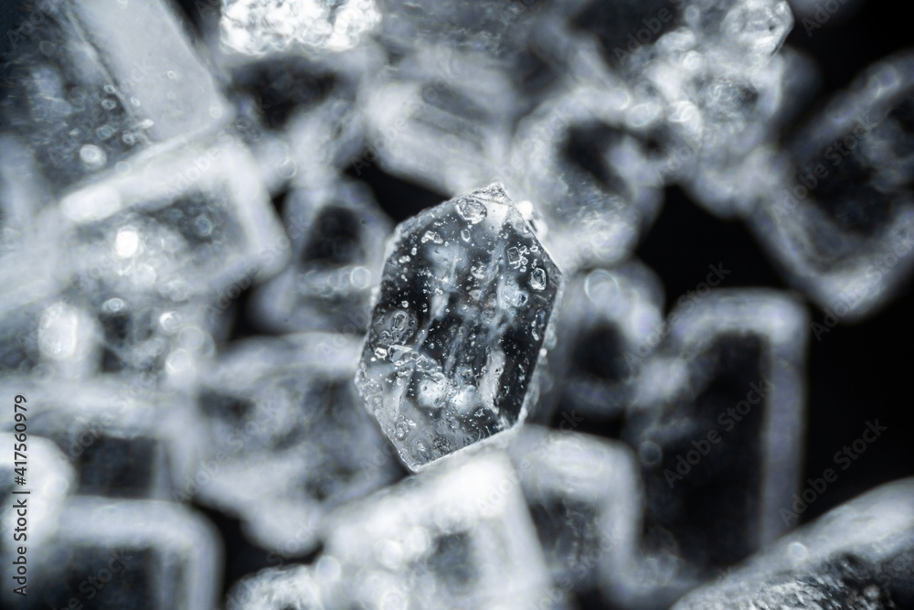 Crystal sugar close up on black background under the light microscope ...