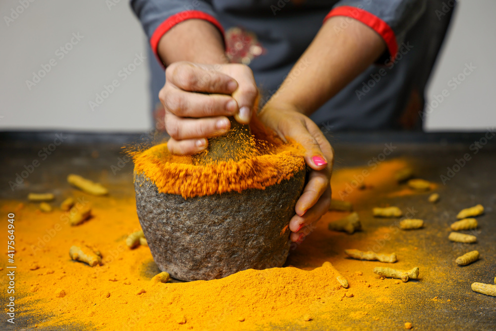 Woman hand powdering Indian spices turmeric powder splash explosion ...