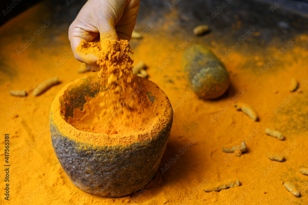 Woman hand powdering Indian spices turmeric powder stone mortar Kerala ...